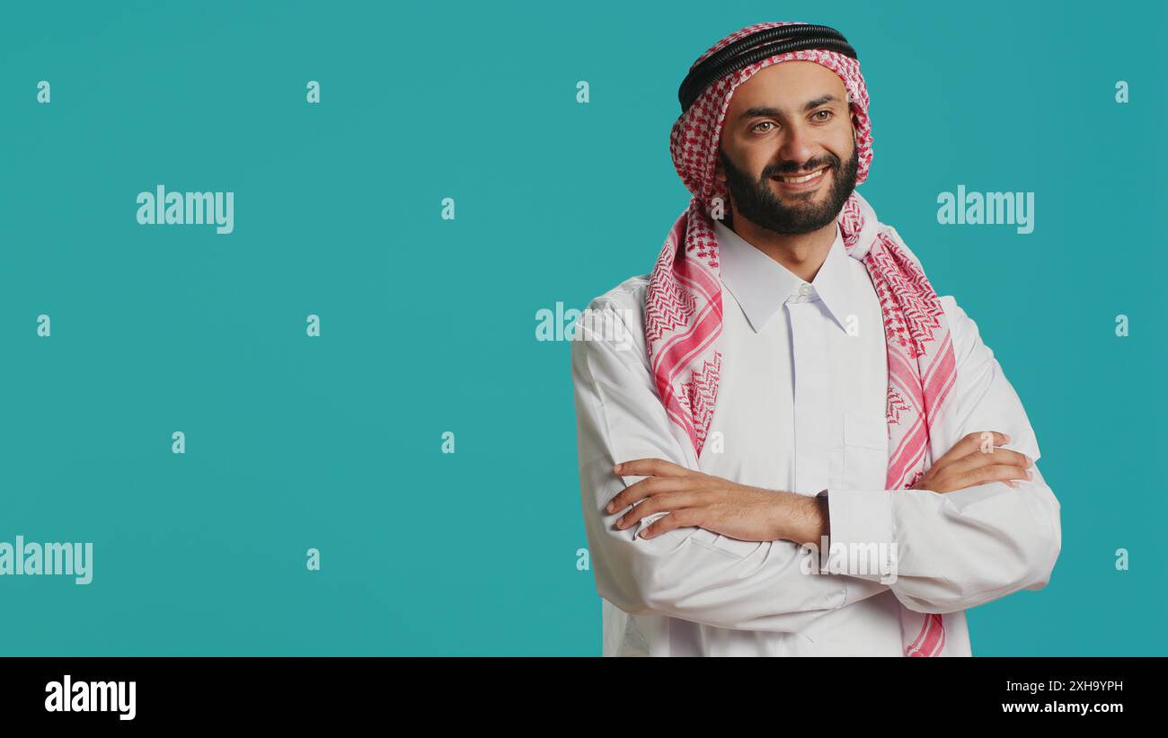 Adult in traditional thobe and kufiyah appears delighted, representing ...