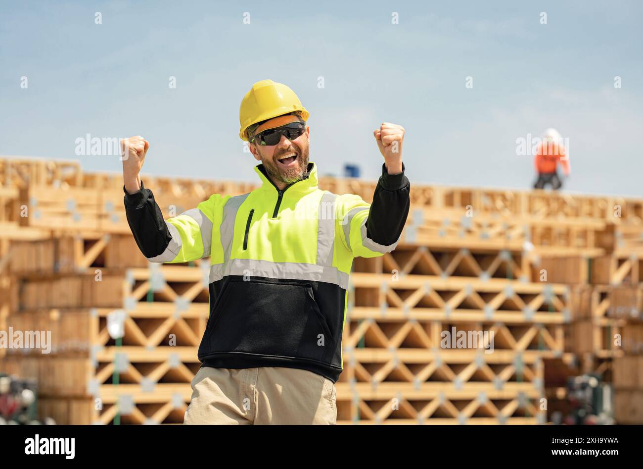 Excited, amazed builder near american wood frame house construction ...