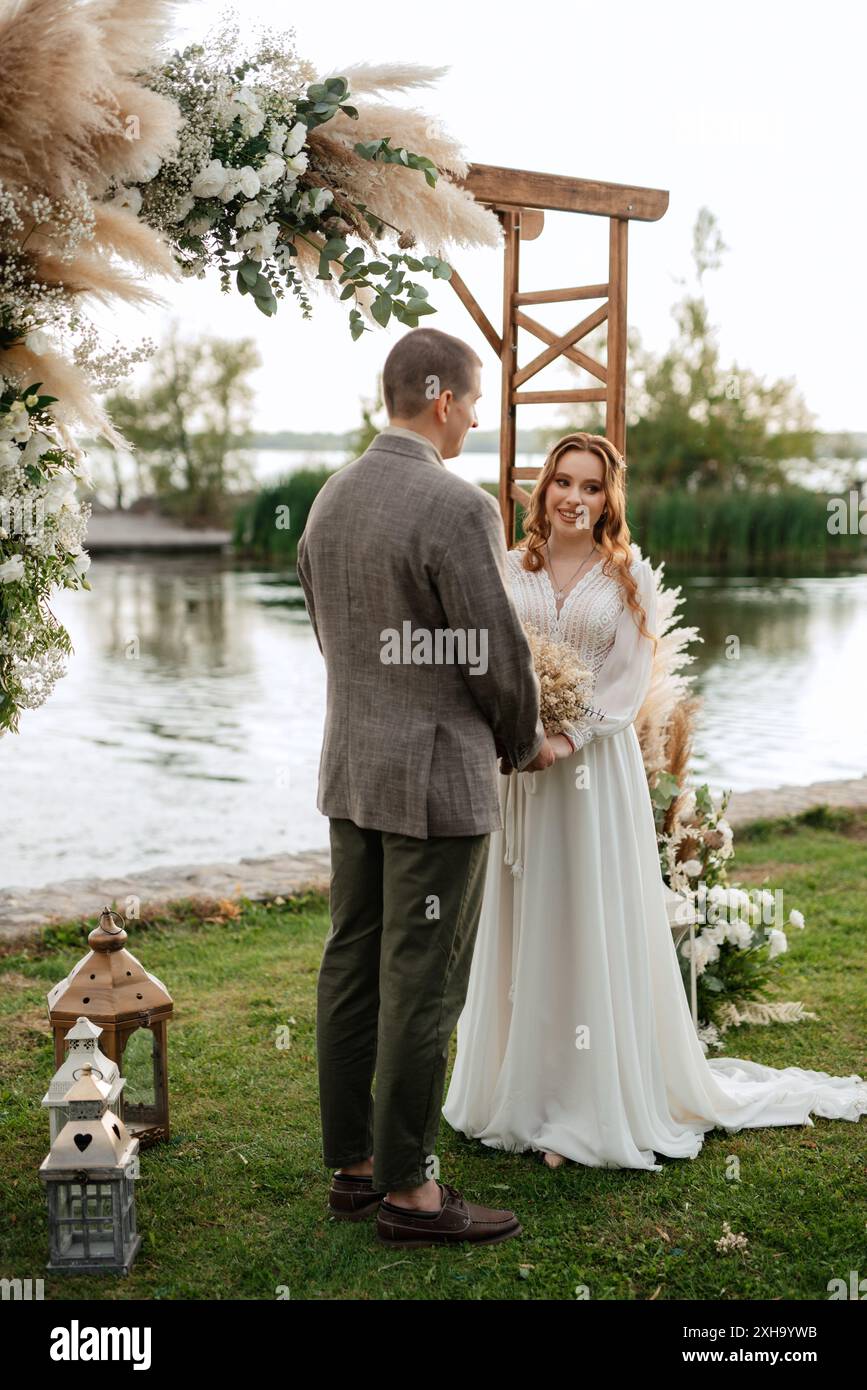 wedding ceremony of the newlyweds in a country cottage on a green hill ...