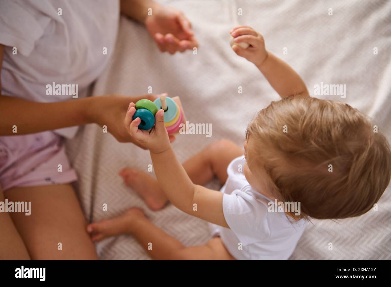 Top view of a baby playing with colorful stacking toy blocks with ...