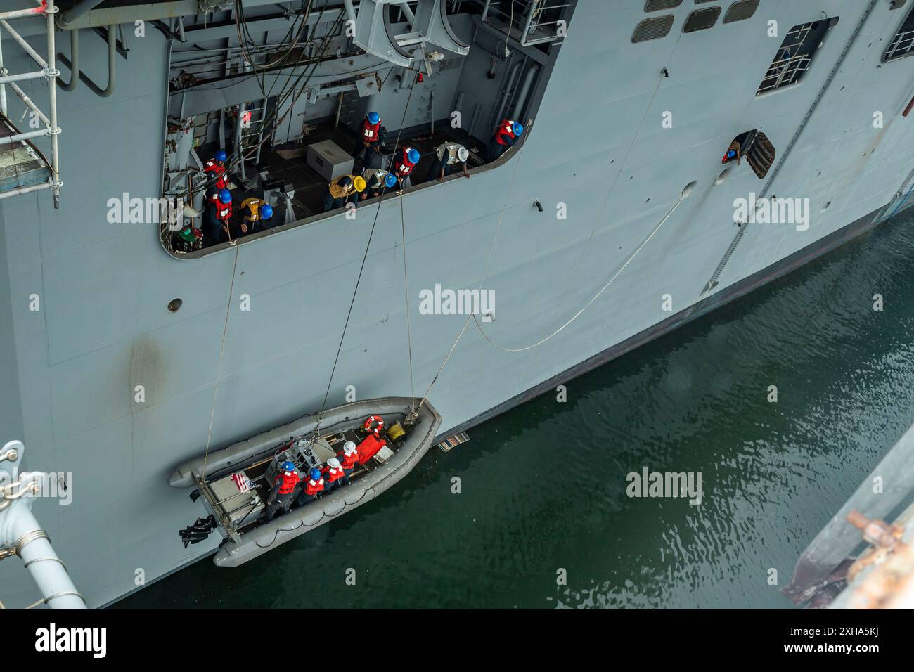 Sailors assigned to amphibious assault ship USS Essex (LHD 2) lower a ...