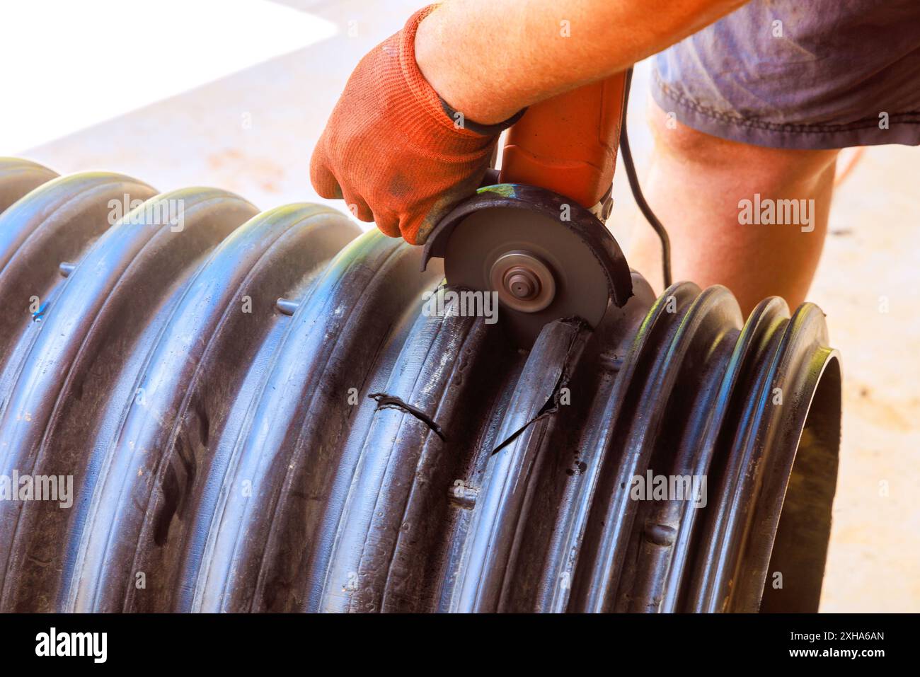 Hole is cut in black plastic polypropylene sanitary pipe to facilitate ...