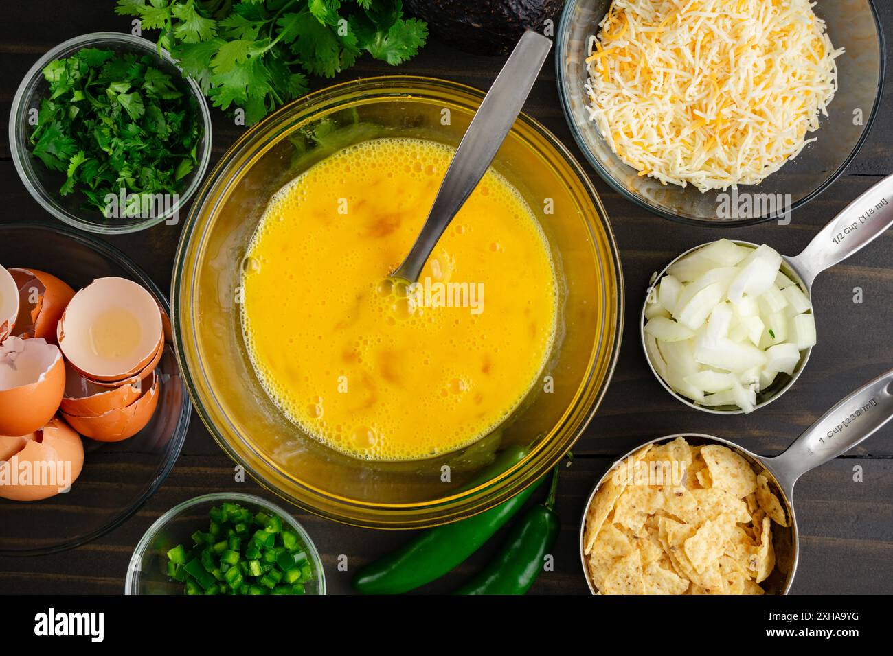 Beaten Eggs in a Glass Mixing Bowl with a Fork: Eggs for migas surrounded with tortilla chips ...