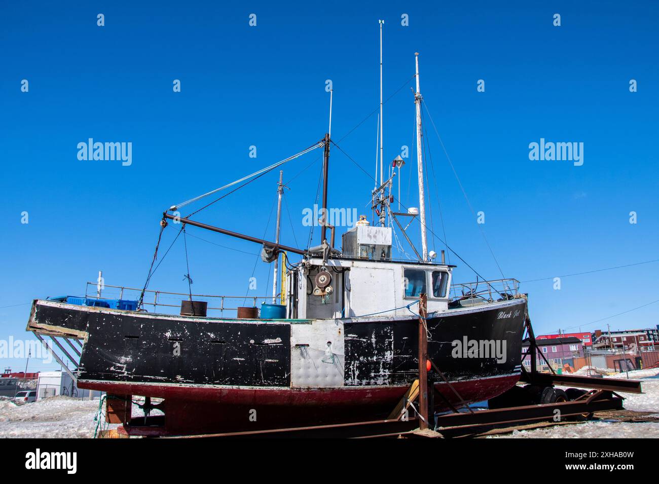 Black Jet boat stored on the beach on Frobisher Bay in Iqaluit, Nunavut ...