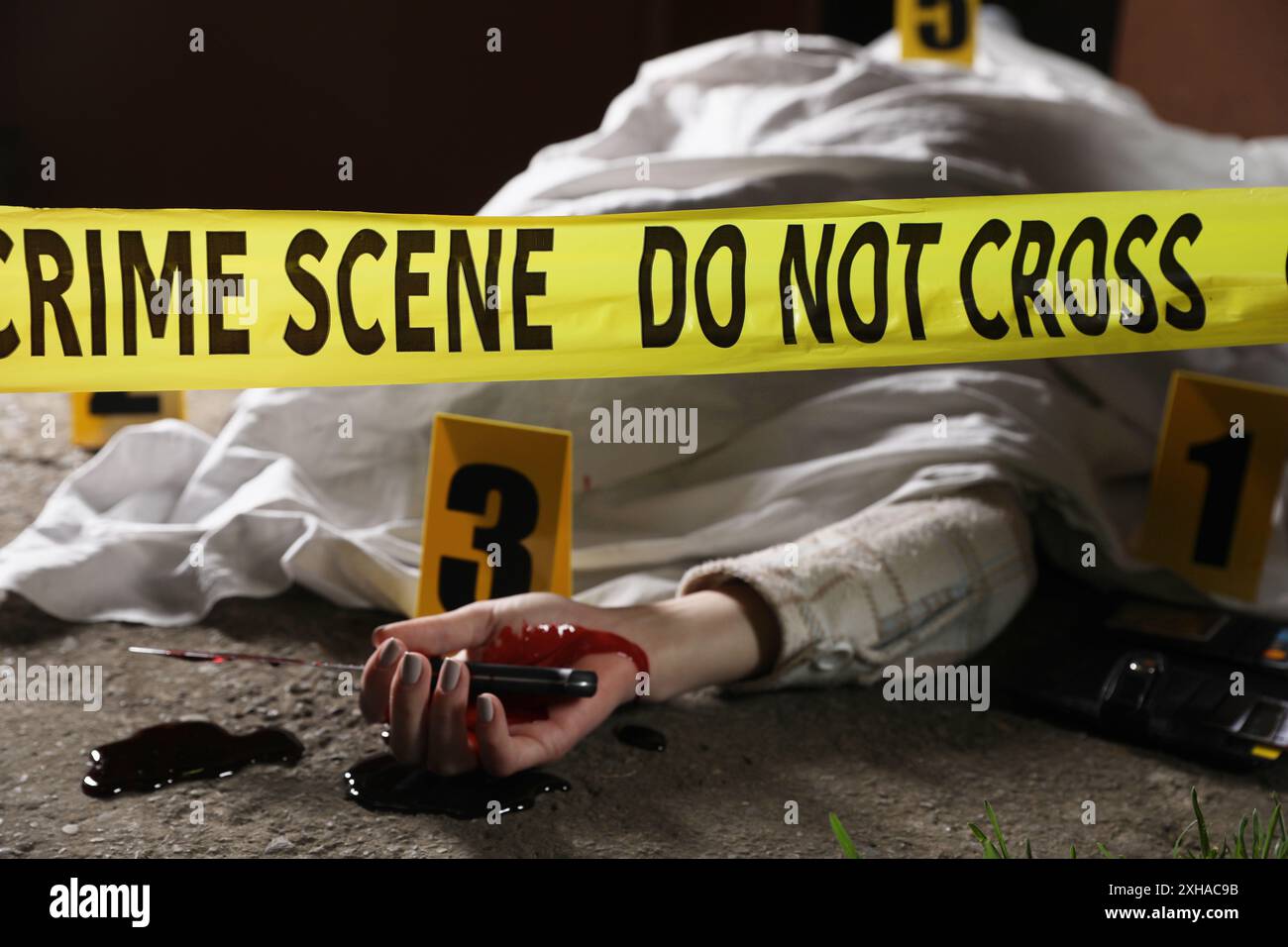 Crime scene with dead woman's body, bloody knife, marker and yellow ...