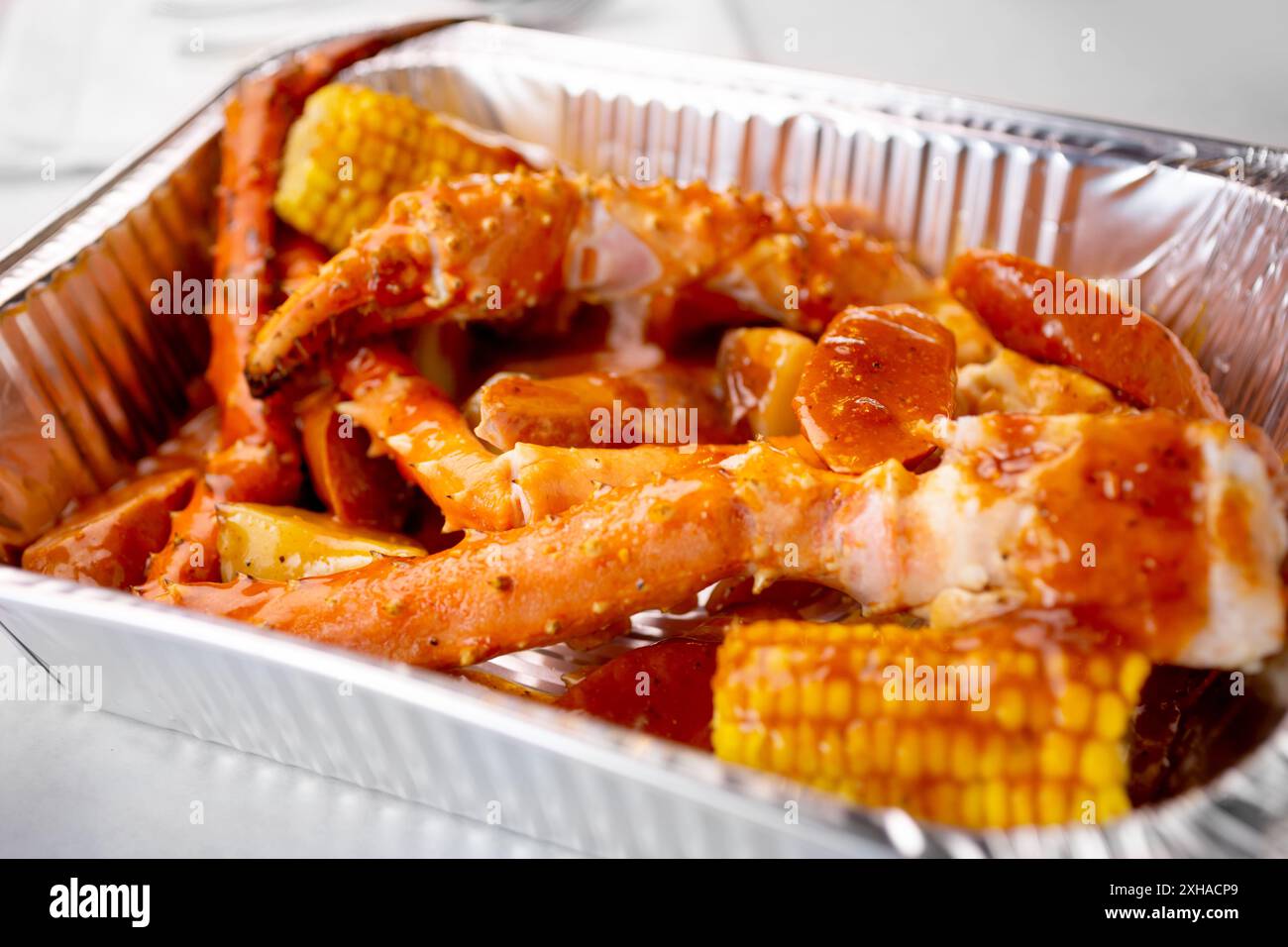 A view of a tin container of king crab legs boil Stock Photo - Alamy
