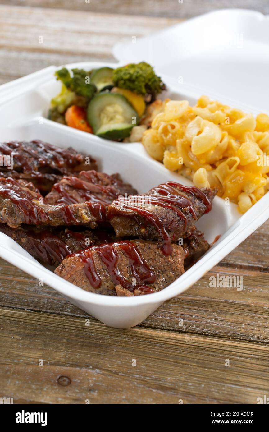 A view of a styrofoam to-go container of BBQ brisket and tri-tip slices ...