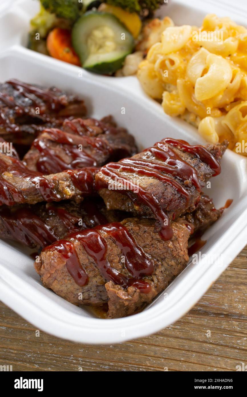 A view of a styrofoam to-go container of BBQ brisket and tri-tip slices ...