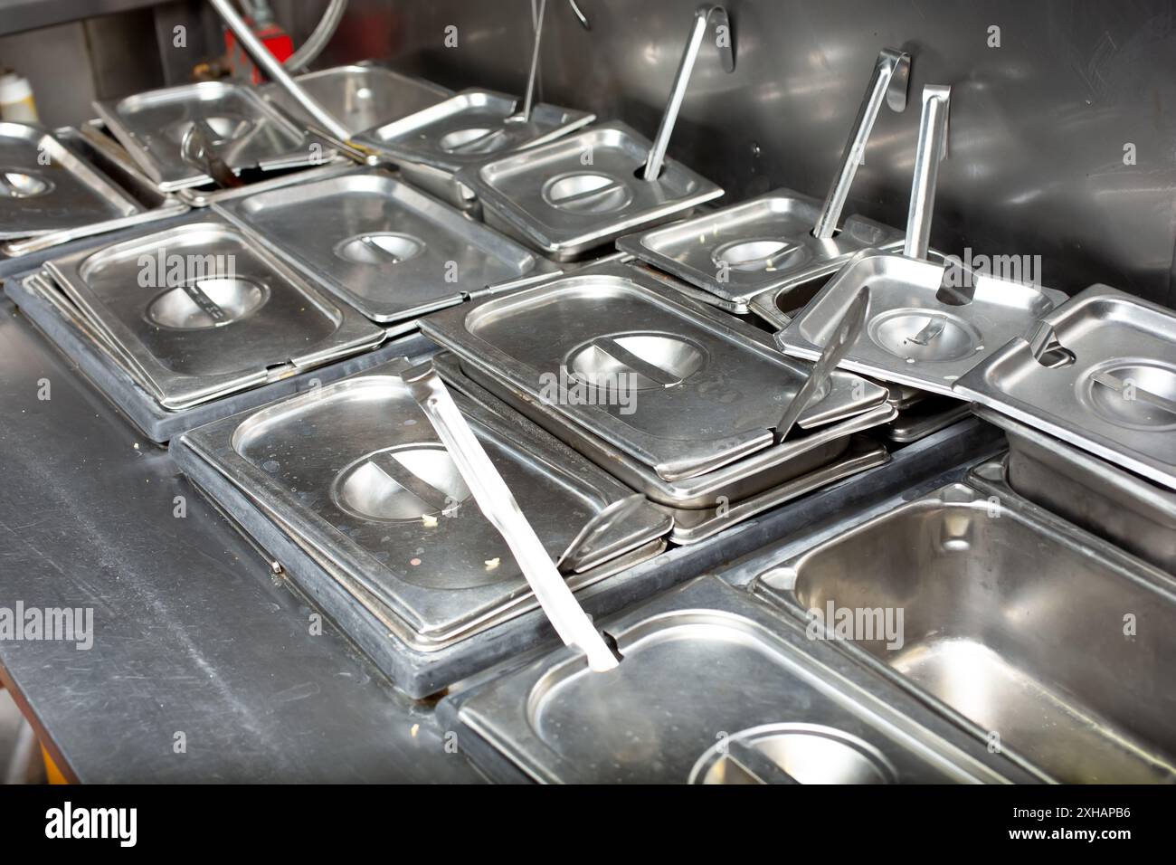 A view of food pan station in a messy fashion, in a restaurant kitchen ...