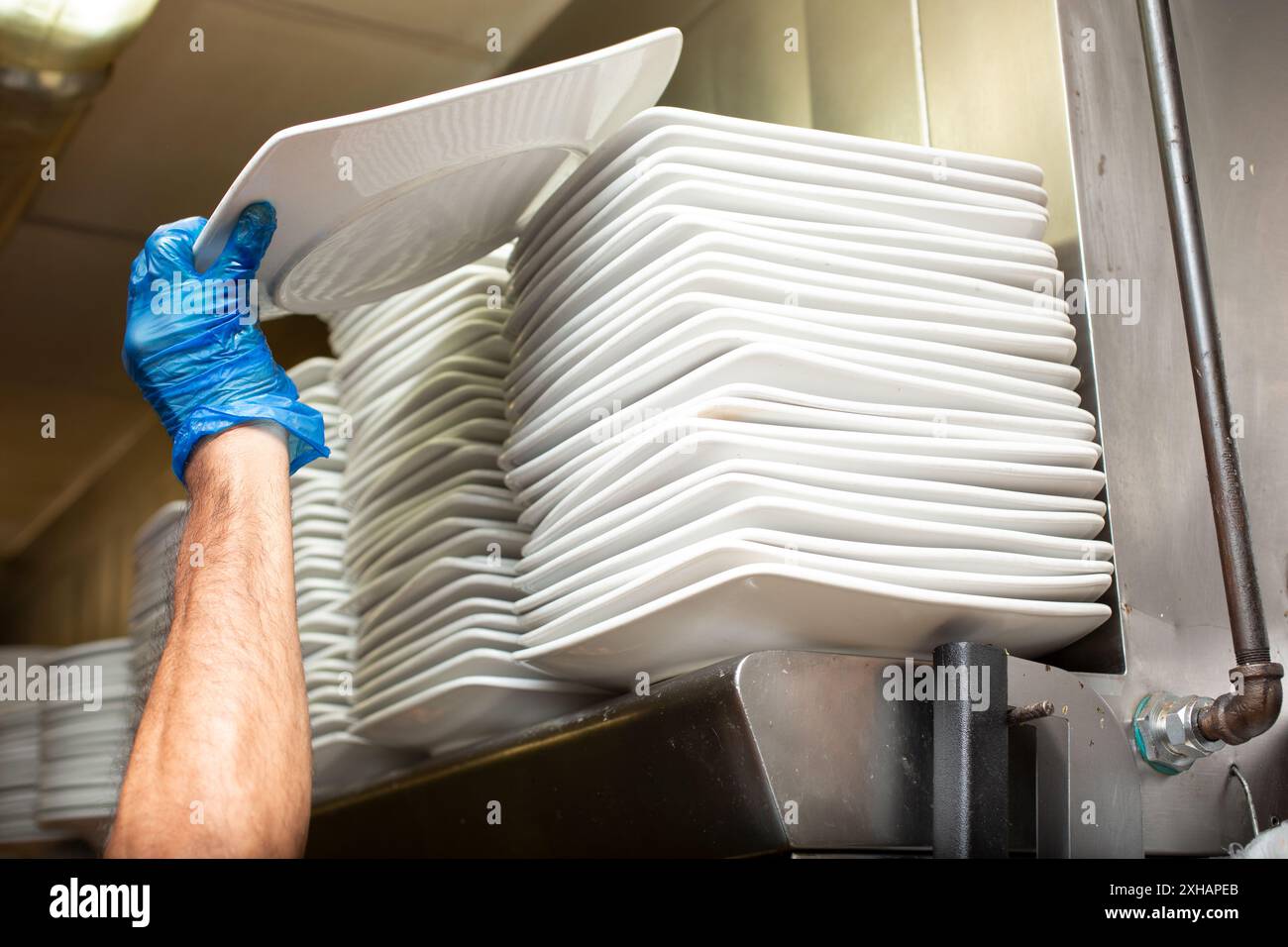 A view of a person grabbing a plate from the stack, in a restaurant ...