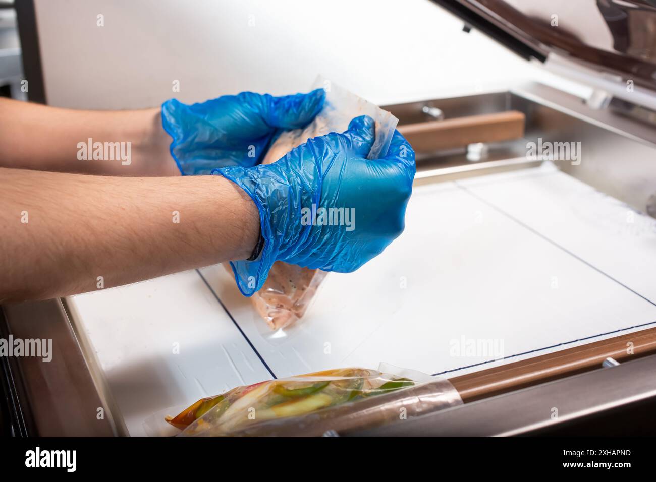 A view of a person using a vacuum packing machine, used in the industry ...