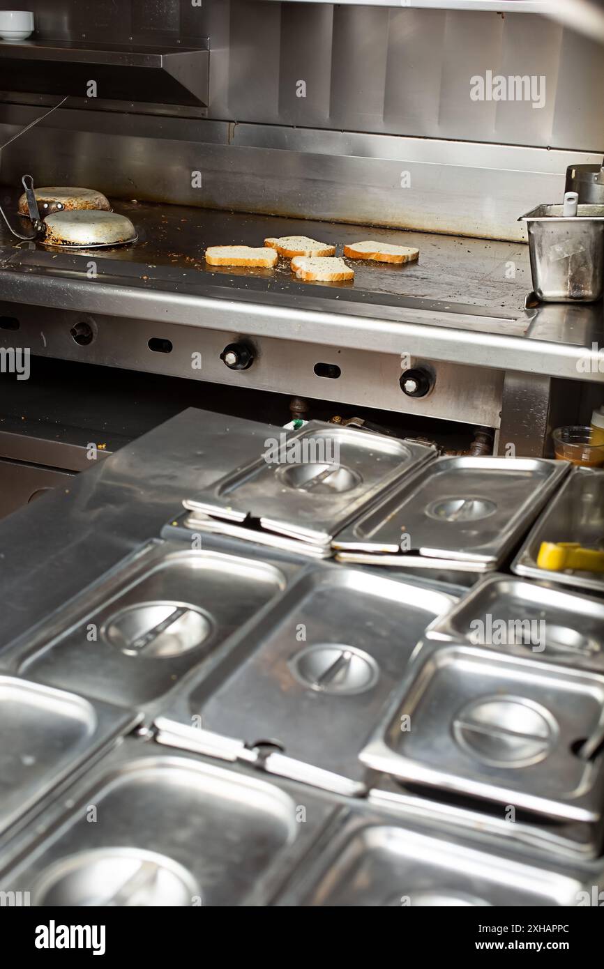 A view of food steamer pan station next to a griddle, in a restaurant ...