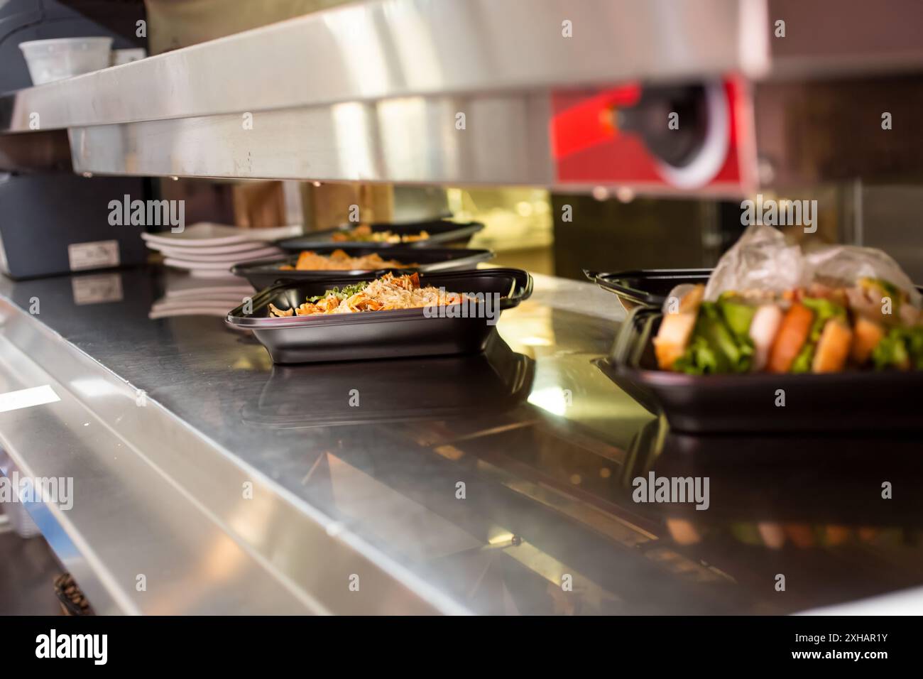 A view of prepared to-go food order containers resting inside a pass ...