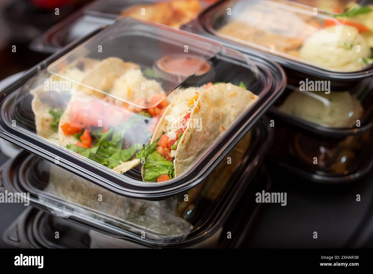 A view of several entrees prepared inside to-go plastic containers ...