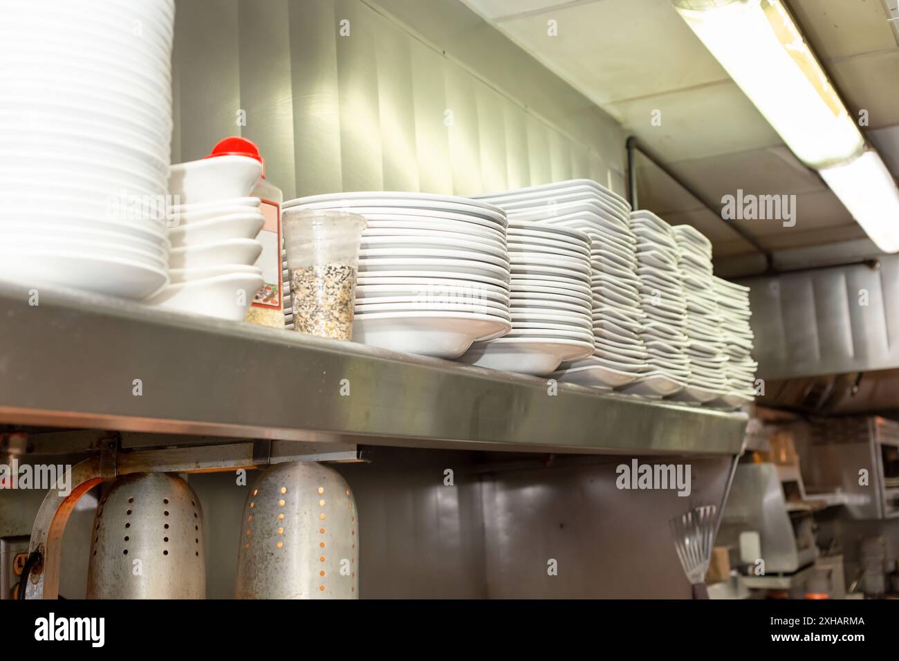 A view of a shelf featuring several stacks of white plates on, in a ...