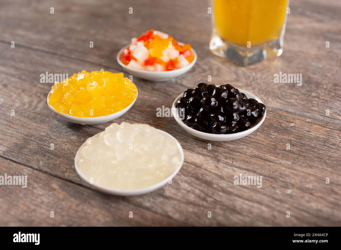 A view of several saucers of fruit tea beverage toppings, featuring ...