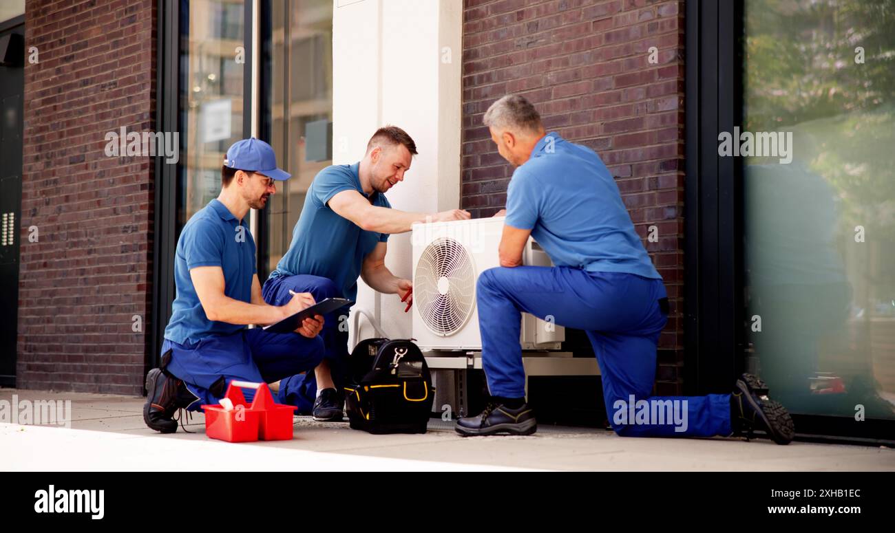 Skilled HVAC technician installing air conditioner unit in commercial ...