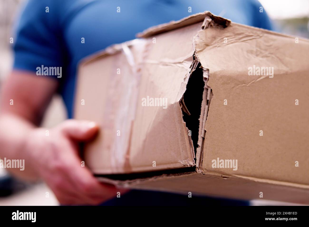 The young mailman was carefully carrying a fragile box for delivery ...