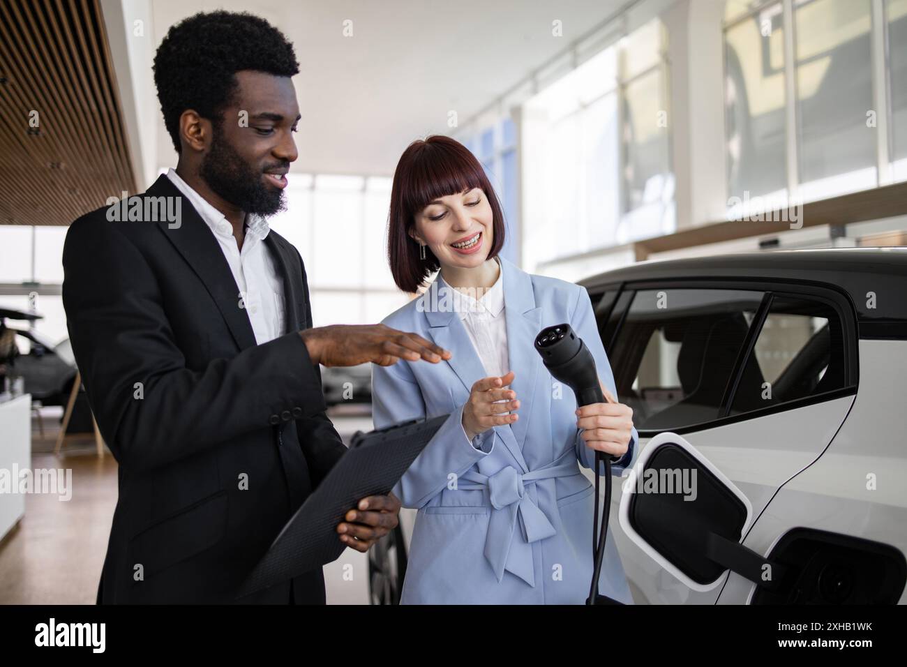 Dealer sells electric SUV to business woman at dealership Stock Photo ...