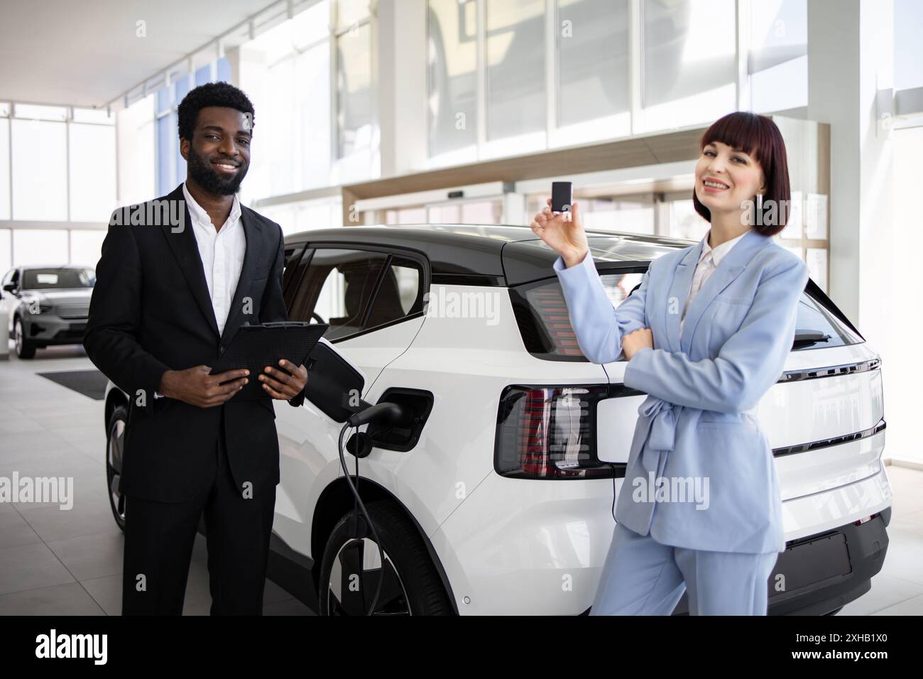 Dealer sells electric SUV to business woman at car dealership Stock ...