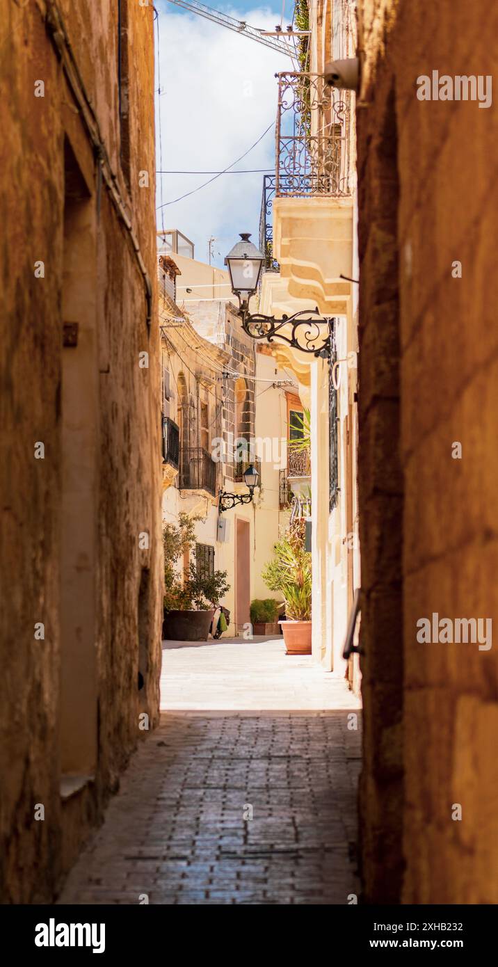 A charming sunlit alleyway in a historic Mediterranean village ...