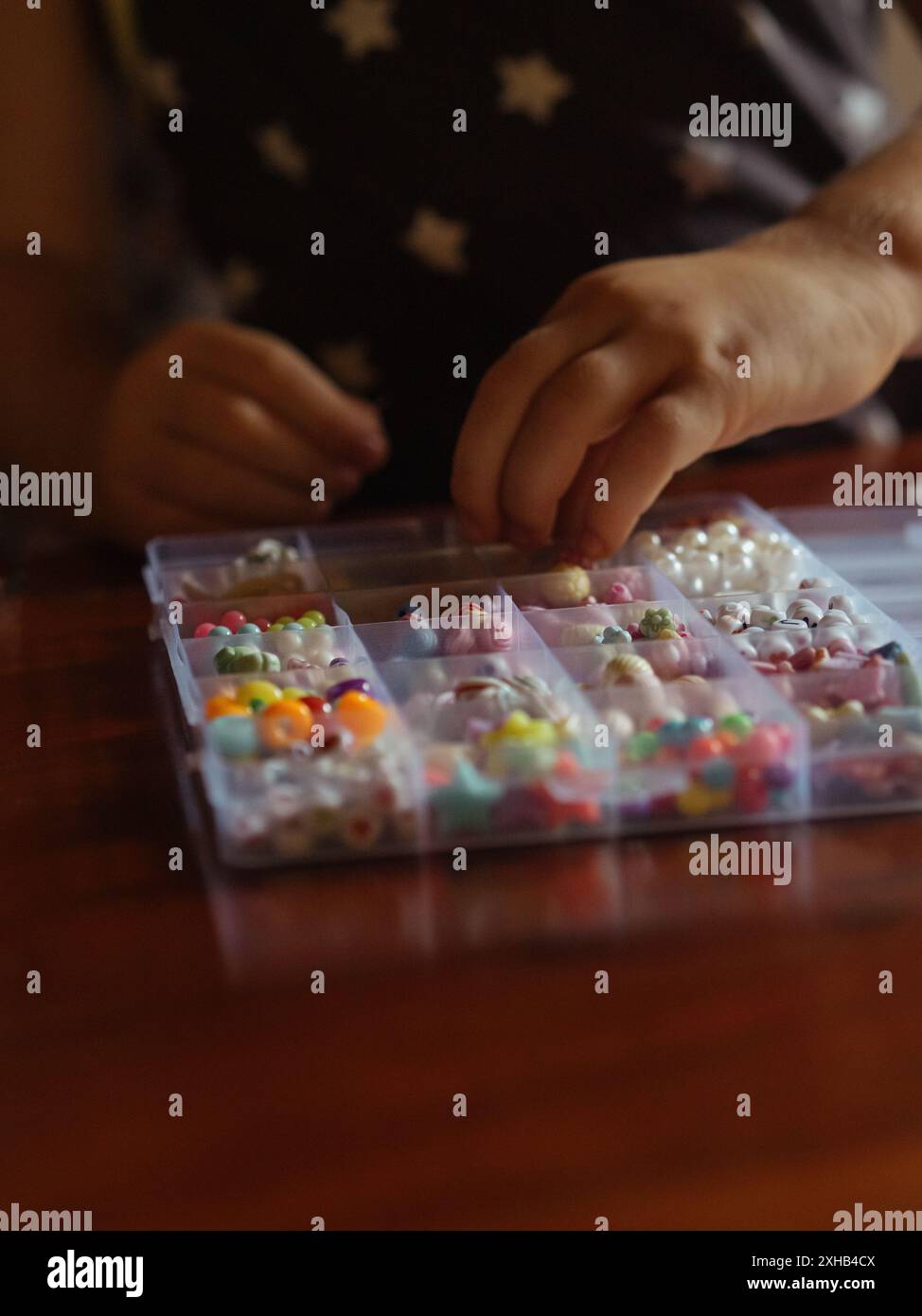 Kid Craft with Beads: A vertical close-up shot captures a toddler girl ...