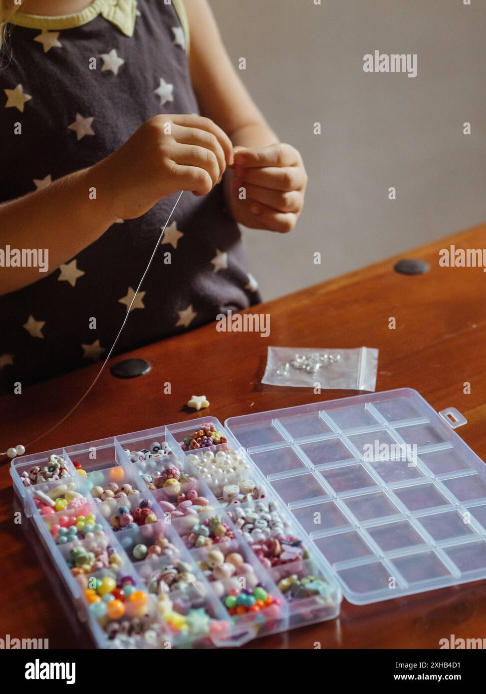Kid Craft with Beads: A vertical close-up shot captures a toddler girl ...