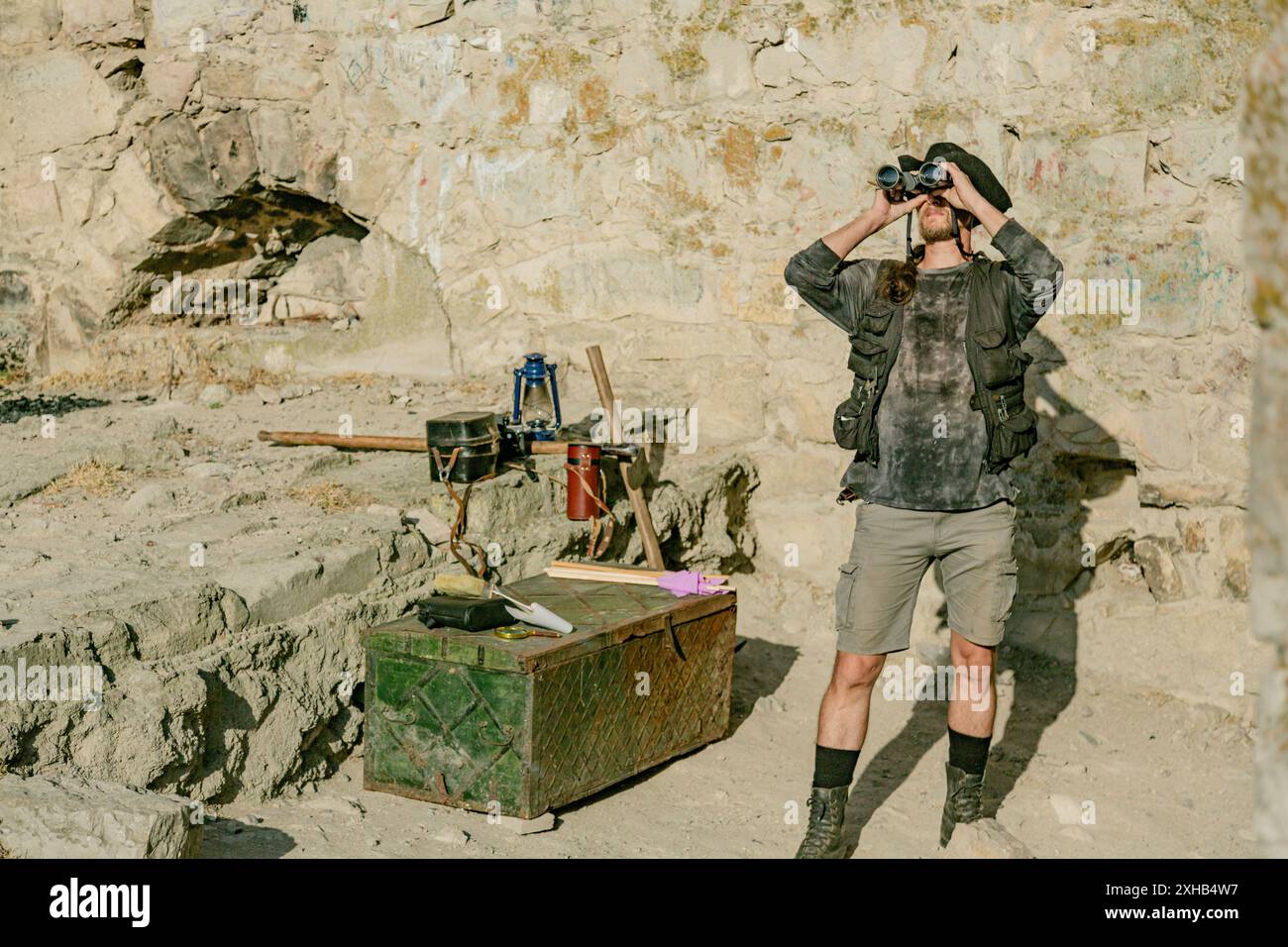 An archaeologist of the last century looks through binoculars against ...