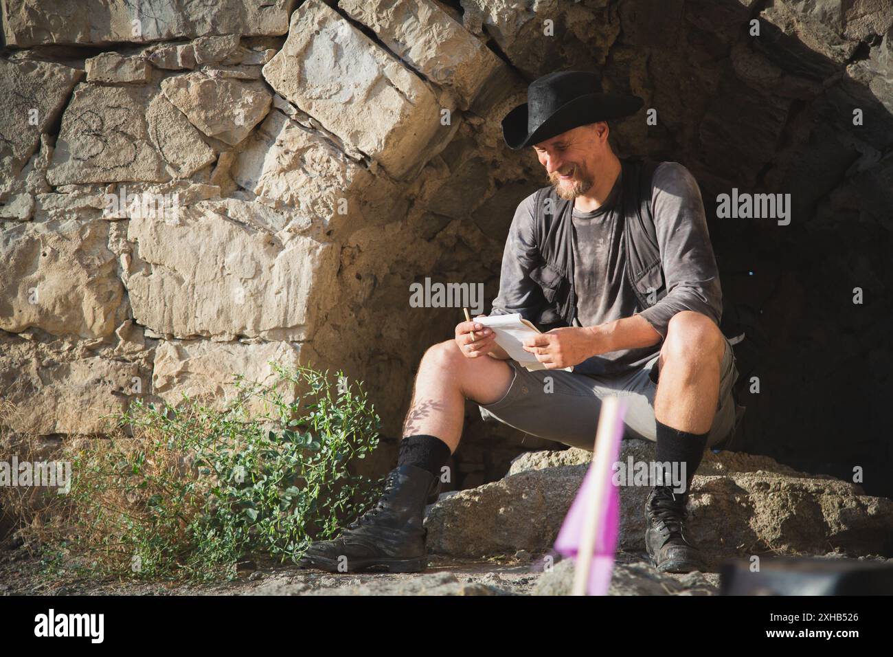 A happy Archaeologist in a costume of the last century works with notes ...
