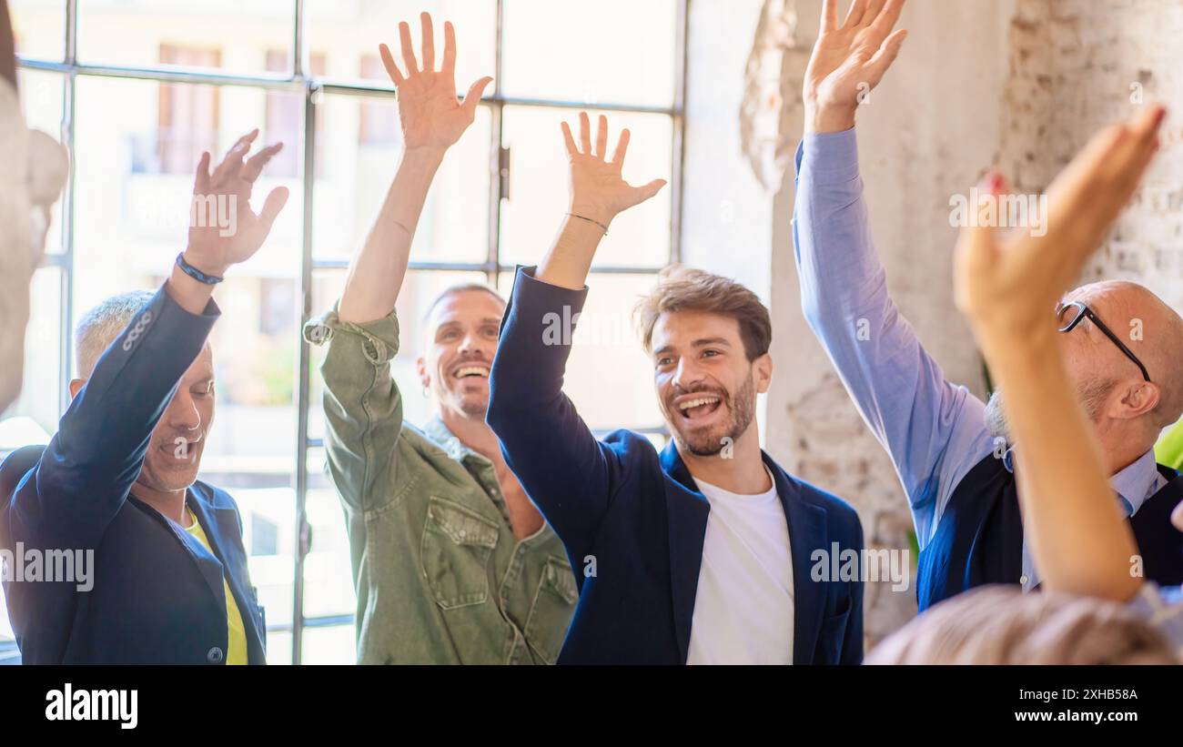 Group of excited professionals with arms raised in triumph. Diverse ...