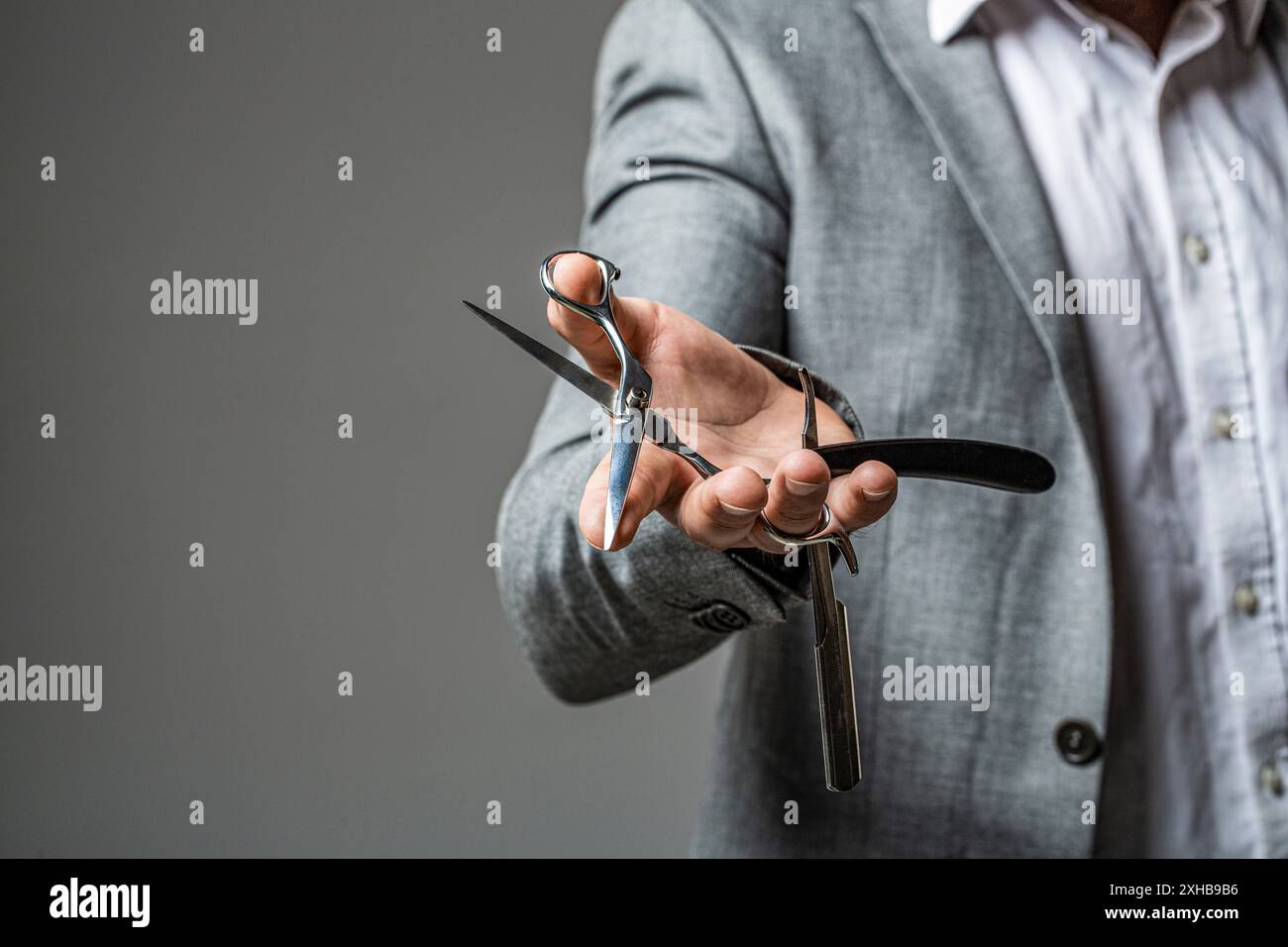 Mens haircut, shaving. Hand, razor, scissors. Man holds in his hand a ...