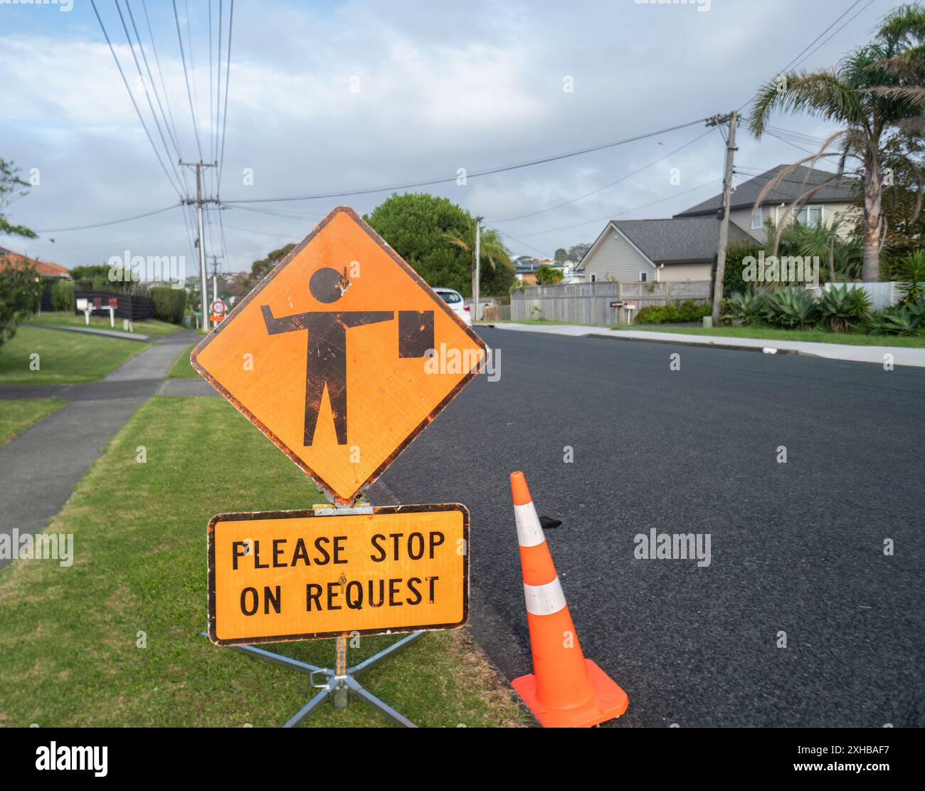 Orange board with Please Stop on Request sign on the side of the road ...