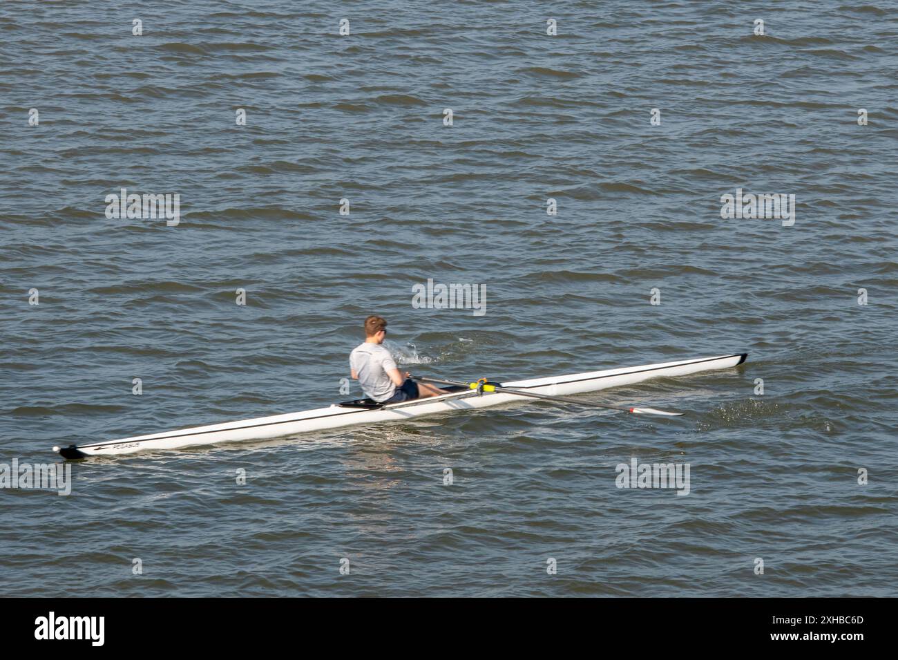 single skull rower training in a single person racing rowing boat Stock ...