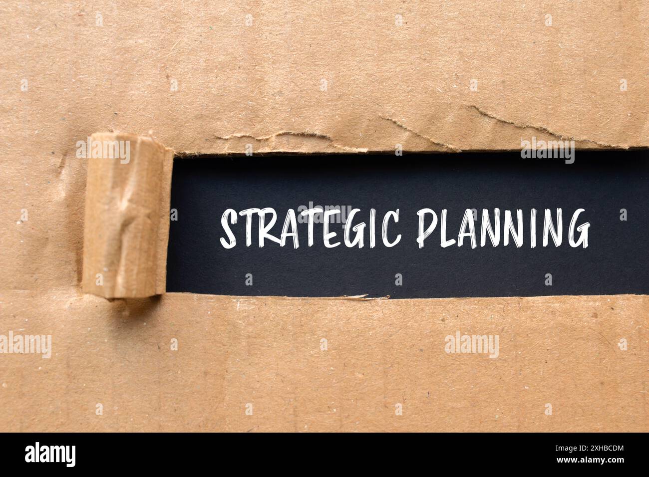 Strategic planning message written on ripped cardboard paper with black ...