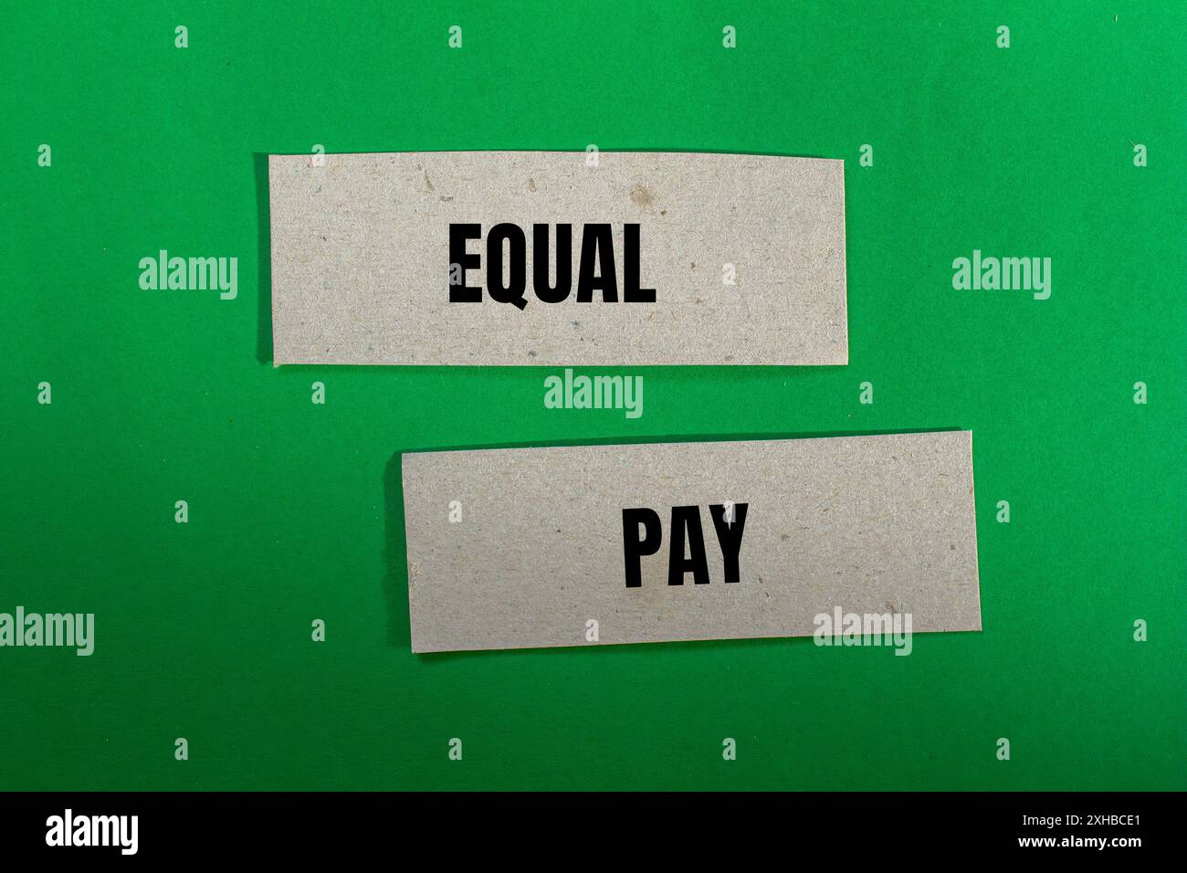 Equal pay message written on paper pieces with green background ...