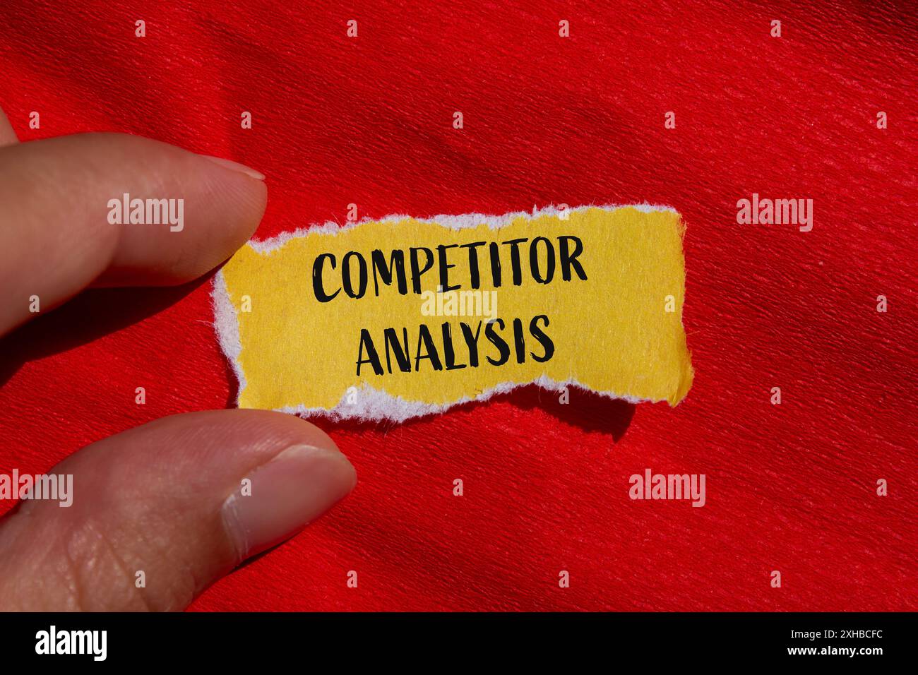 Competitor analysis words written on ripped yellow paper with red ...