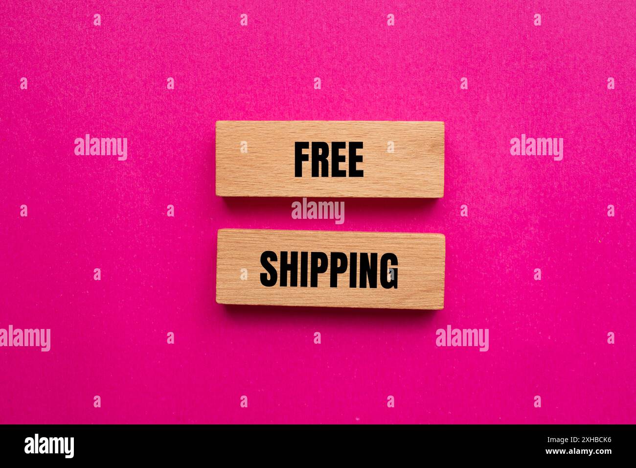 Free shipping message written on wooden blcoks with pink background ...
