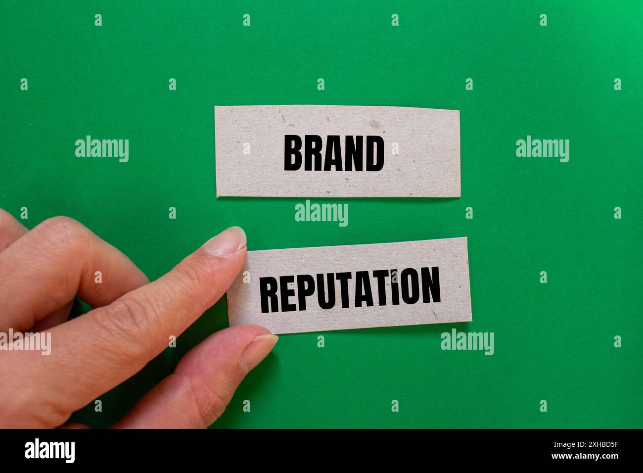 Brand reputation message written on paper pieces with green background ...