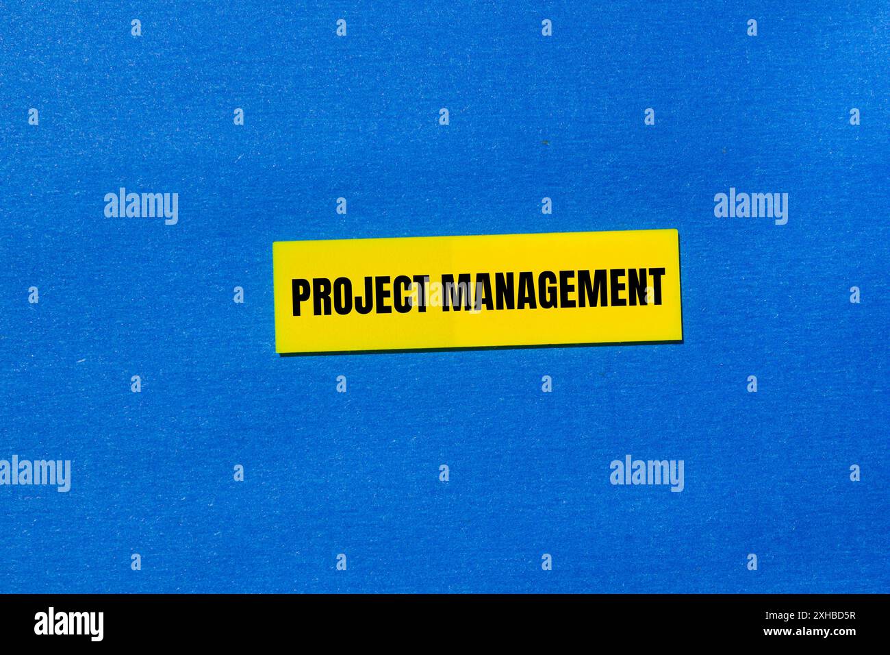 Project management message written on yellow paper with blue background ...