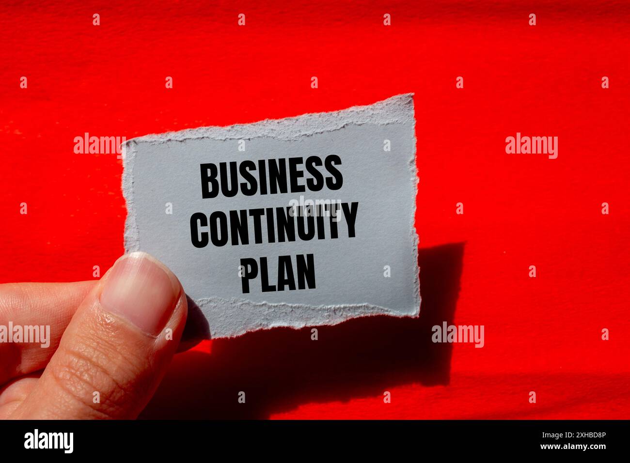 Business continuity plan message written on ripped paper piece with red ...