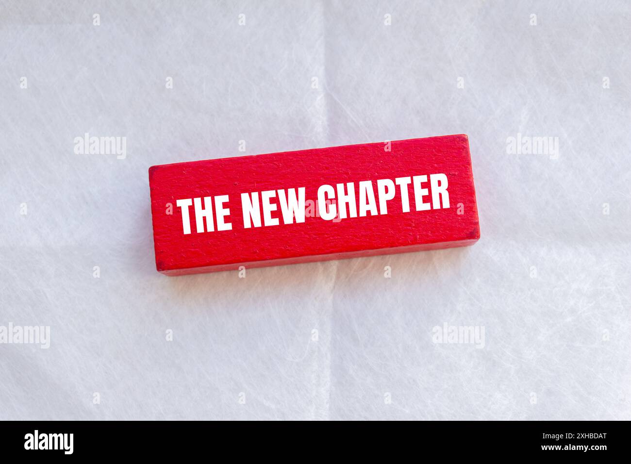 The new chapter words written on red wodoen block with white background ...