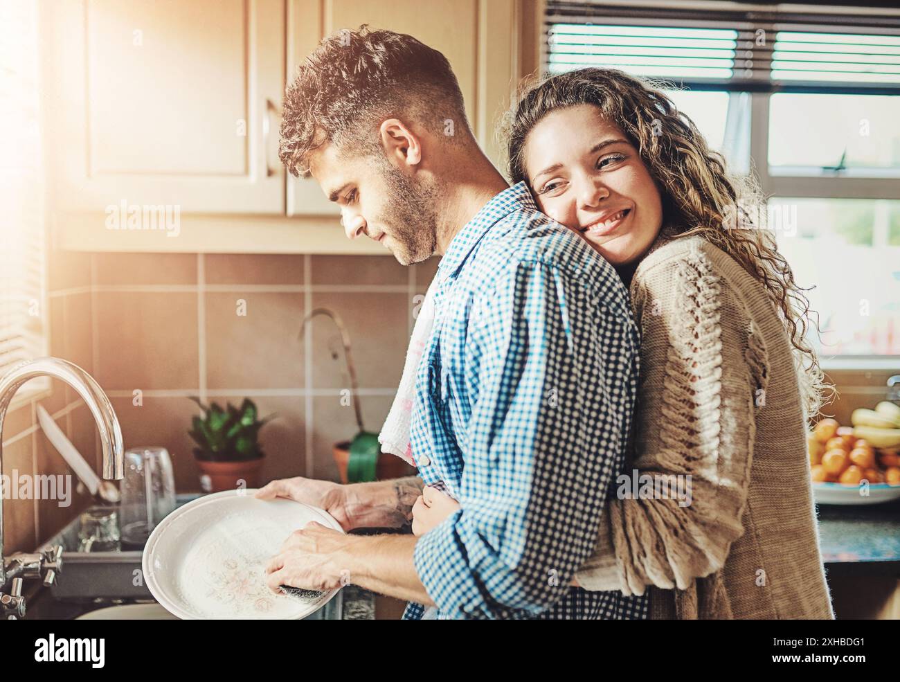 Woman washing dishes man hugging hi-res stock photography and images ...