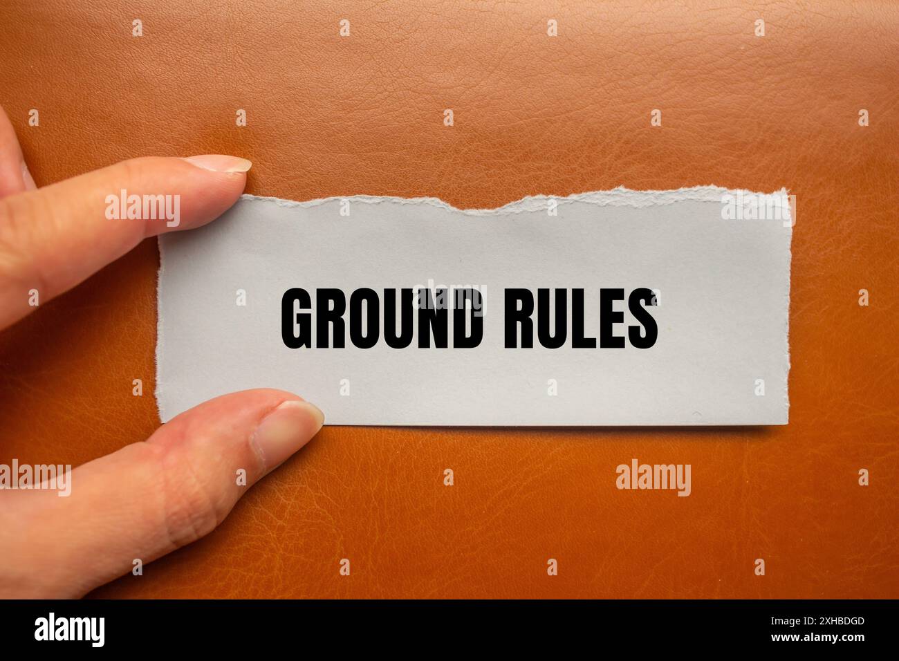 Ground rules message written on ripped paper piece with brown ...