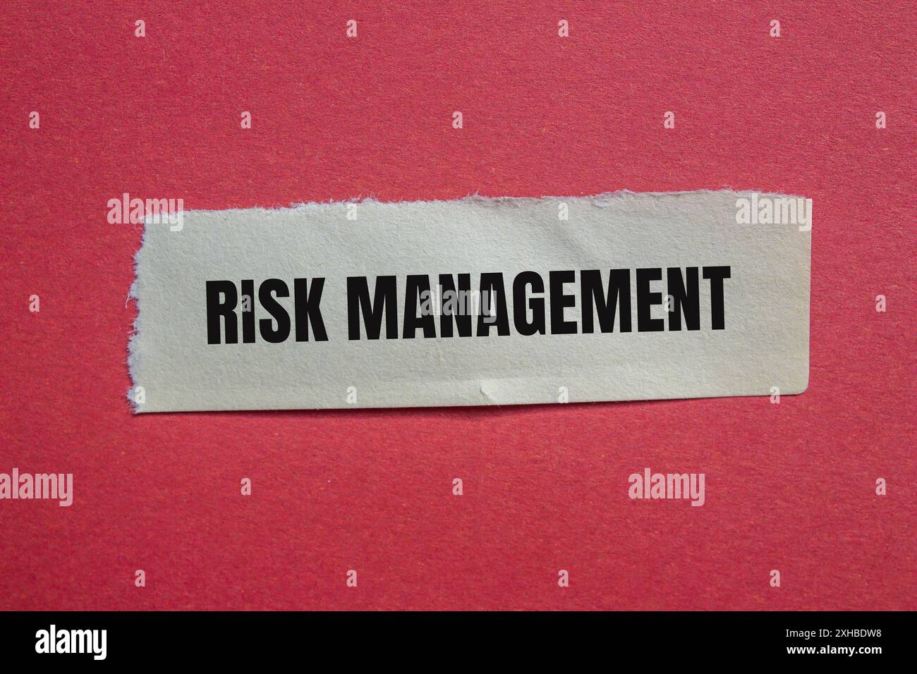 Risk management message written on ripped paper with red background ...