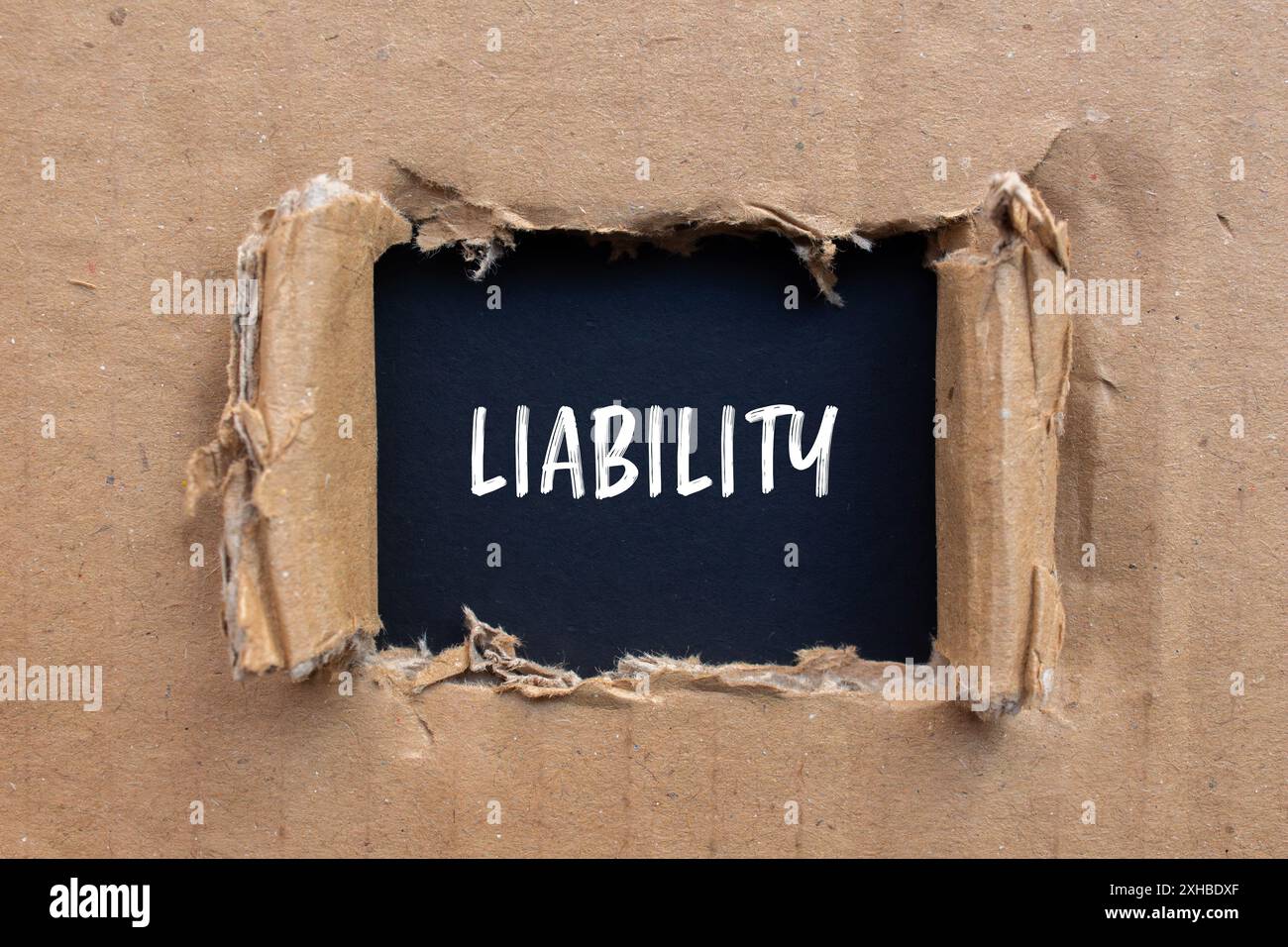 Liability message written on ripped cardboard paper with black ...