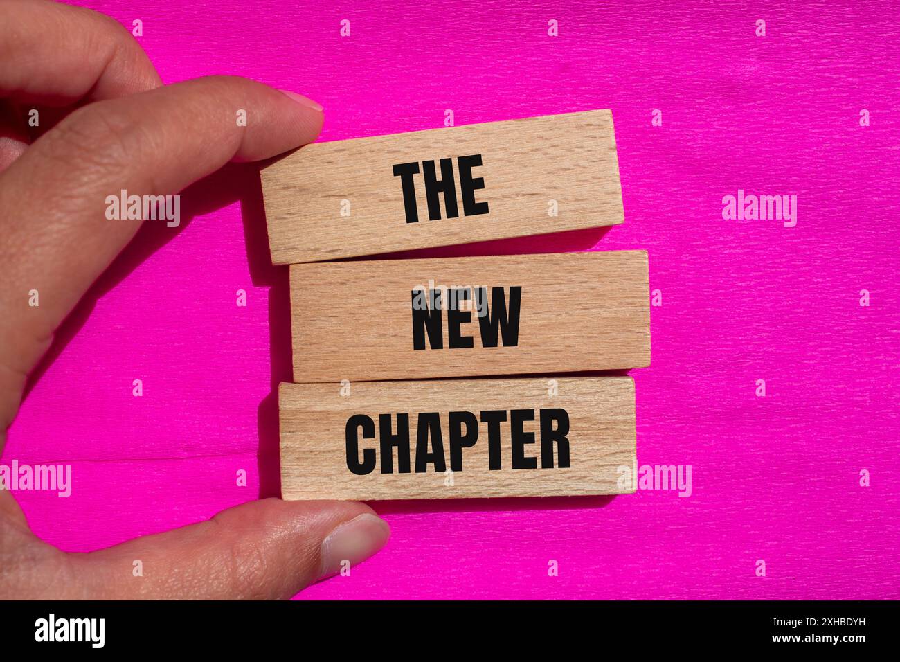 The new chapter words written on wooden blocks with pink background ...