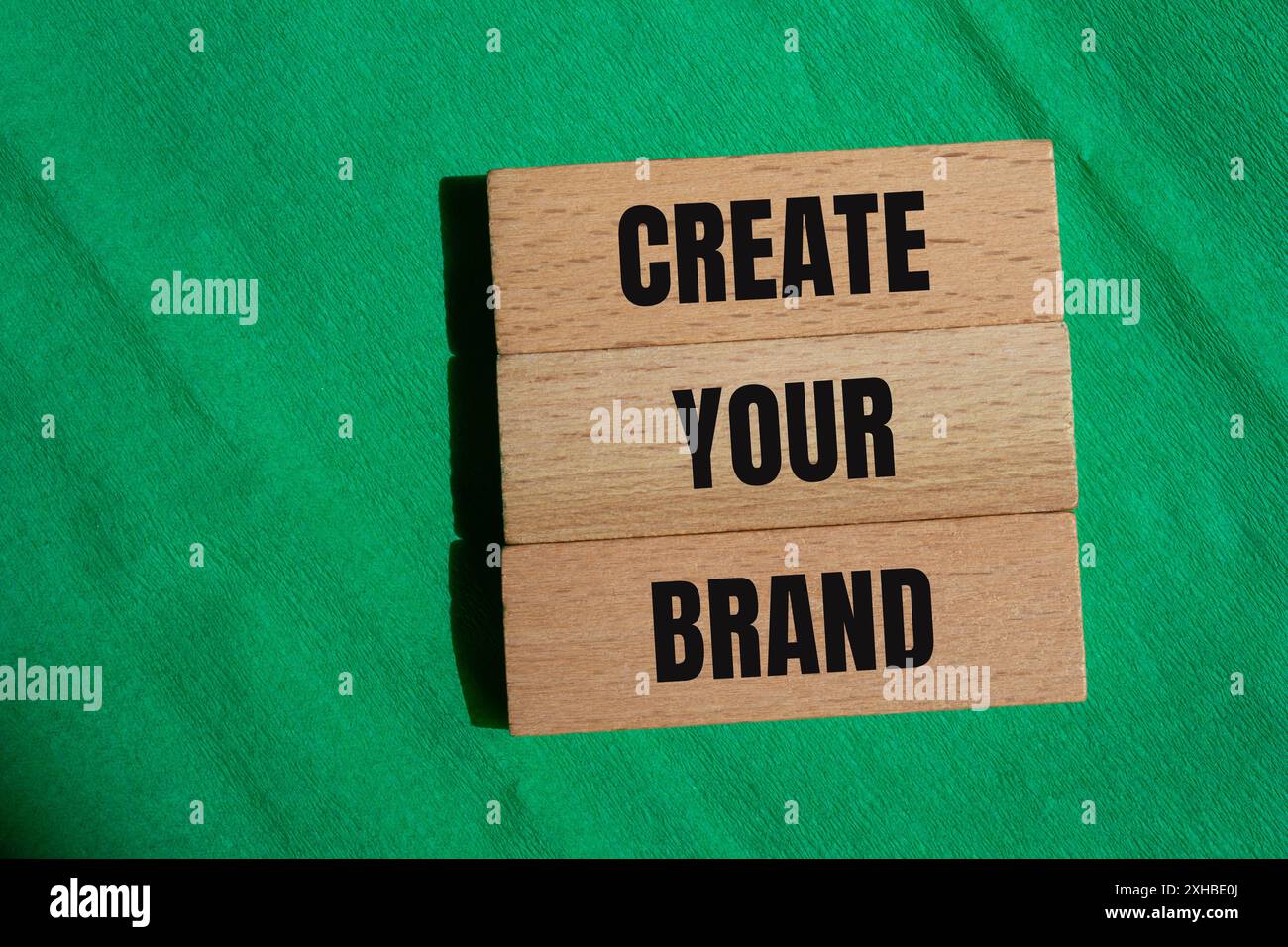 Create your brand words written on wooden blocks with green background ...