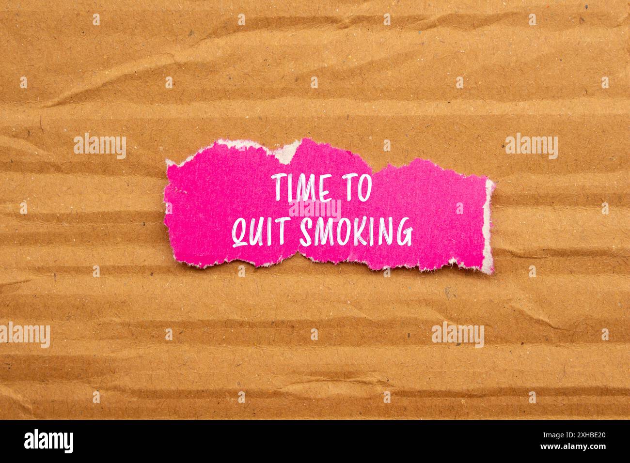 Time to quit smoking message written on ripped pink paper piece with ...
