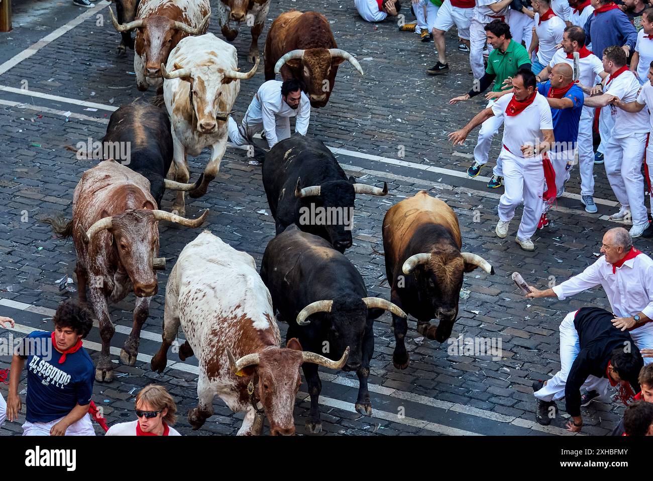 Several runners run in front of the bulls through the streets of ...