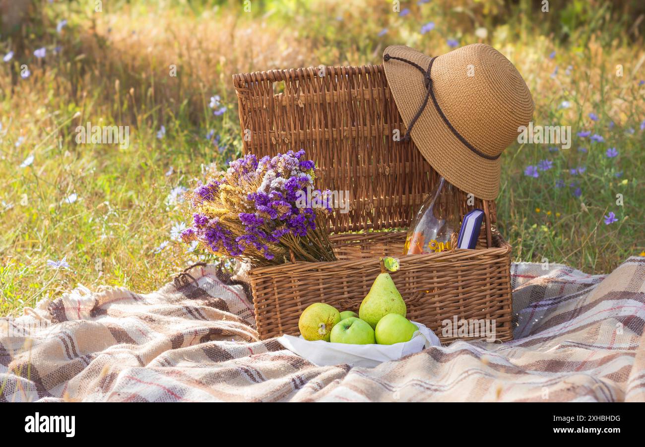Picnic hamper with items and blanket in a late summer meadow Stock ...